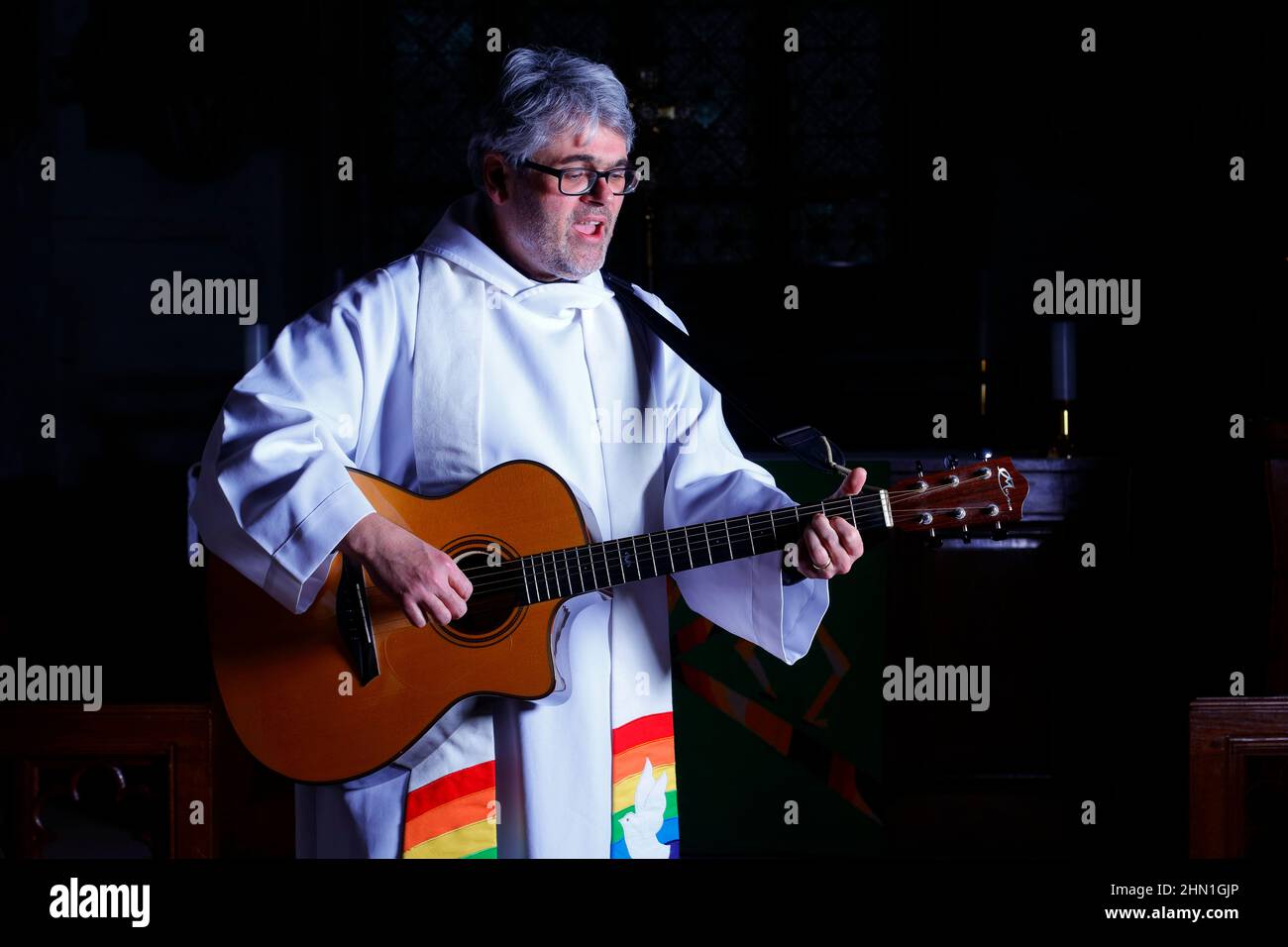 Reverend Bob Bailey playing guitar during one of his church services ...