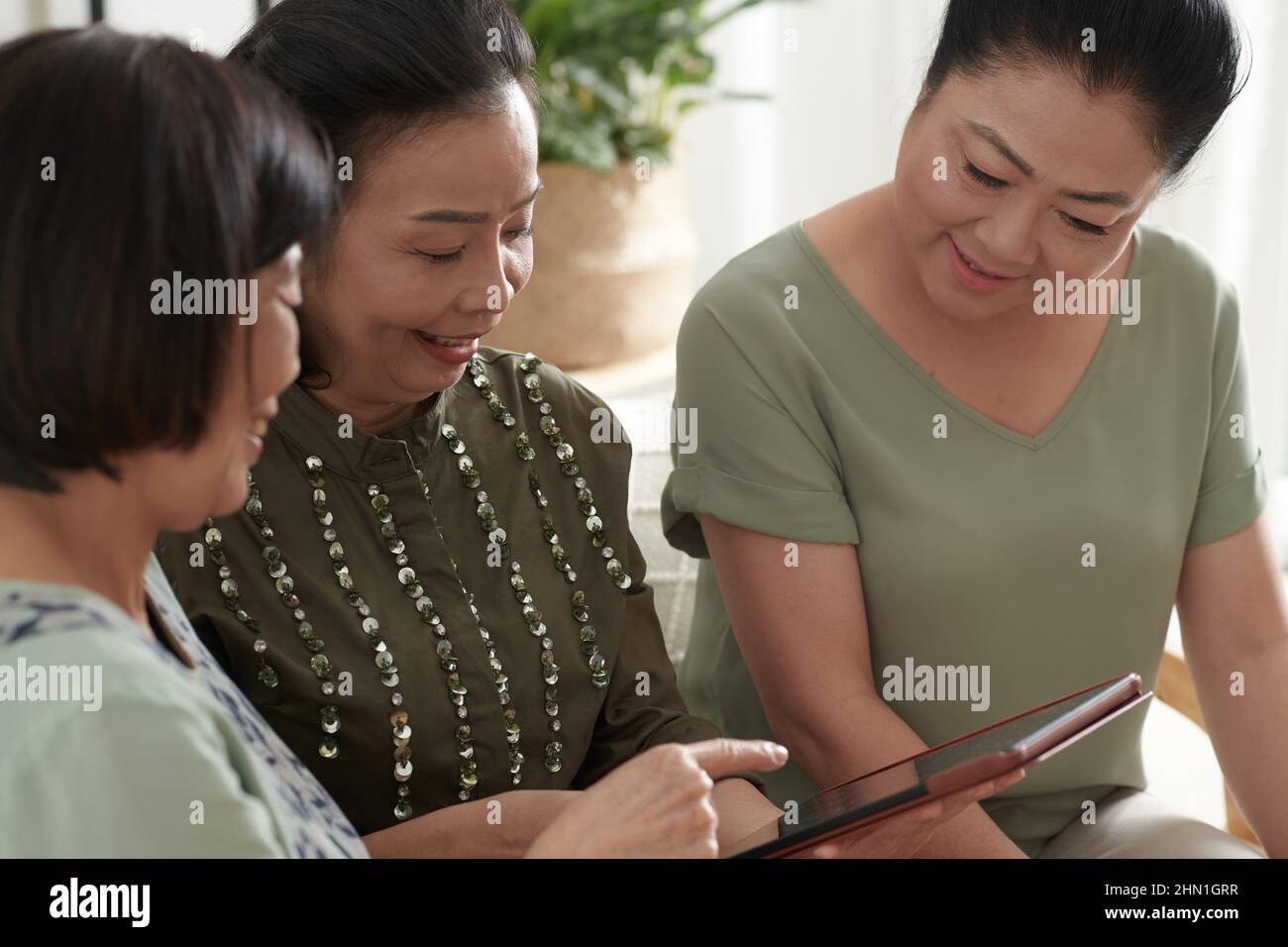 Senior woman explaining her friends how to use new appllication for ...