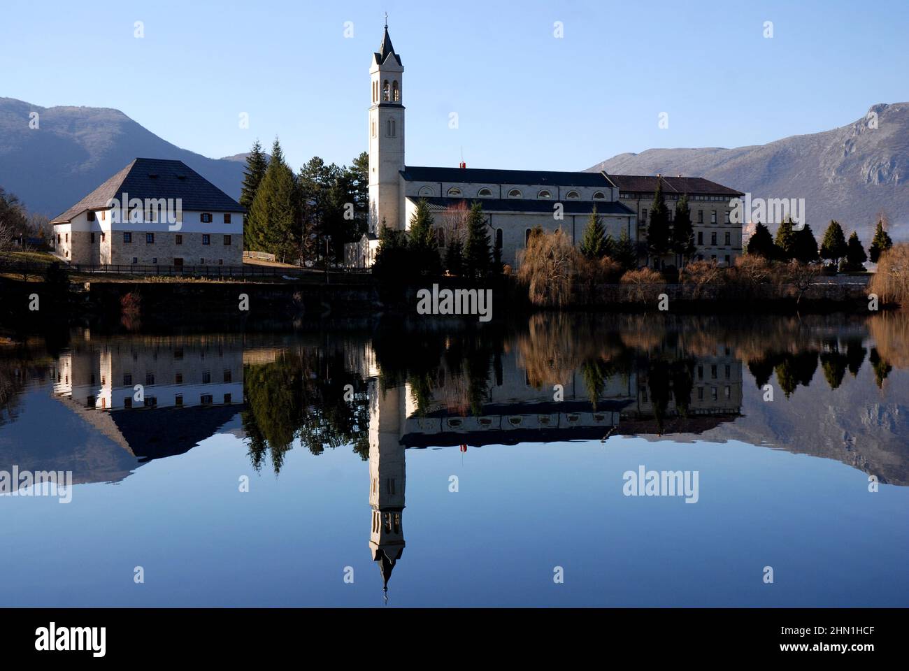 Monastery on an island with reflection in the still water. Autumn ...