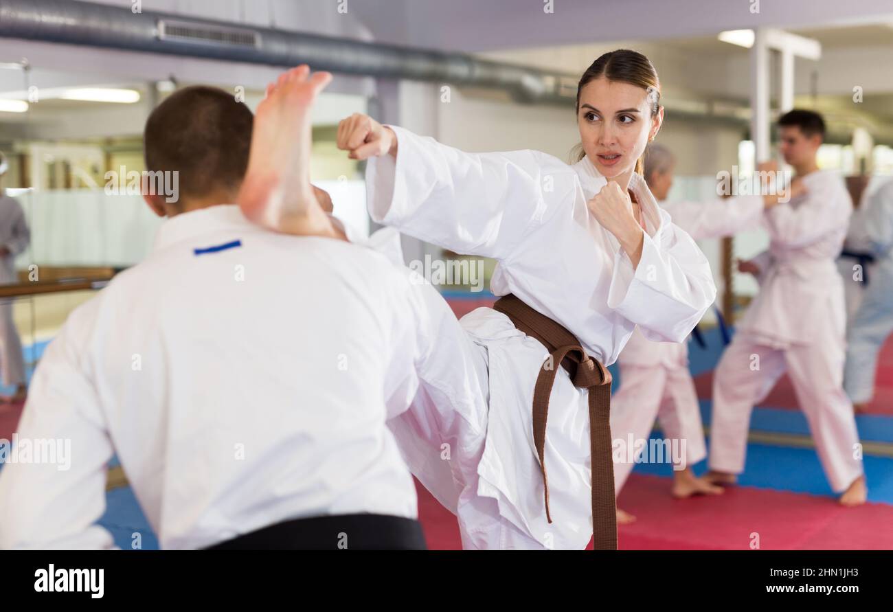 Man and woman in kimono sparring during group karate training Stock ...
