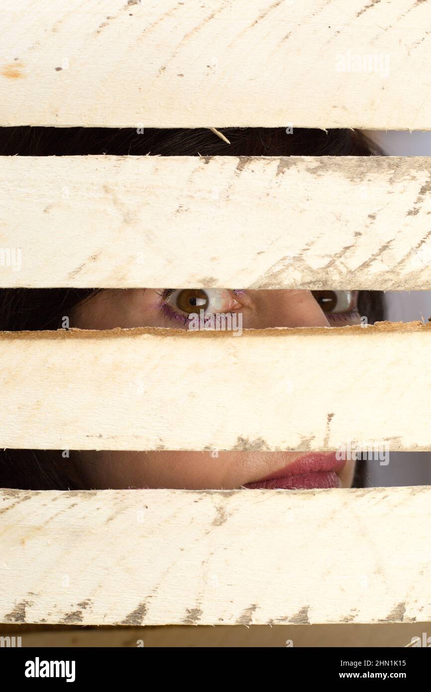 The female eye of a man looking through the gap fence close-up Stock ...
