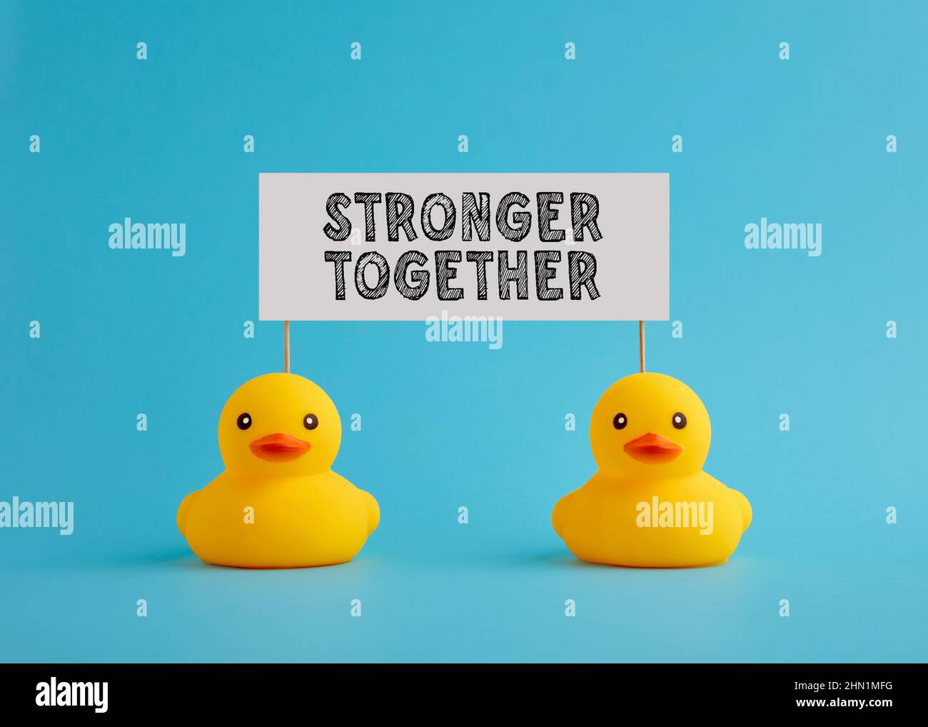 Rubber ducks carry a signboard with the word stronger together ...