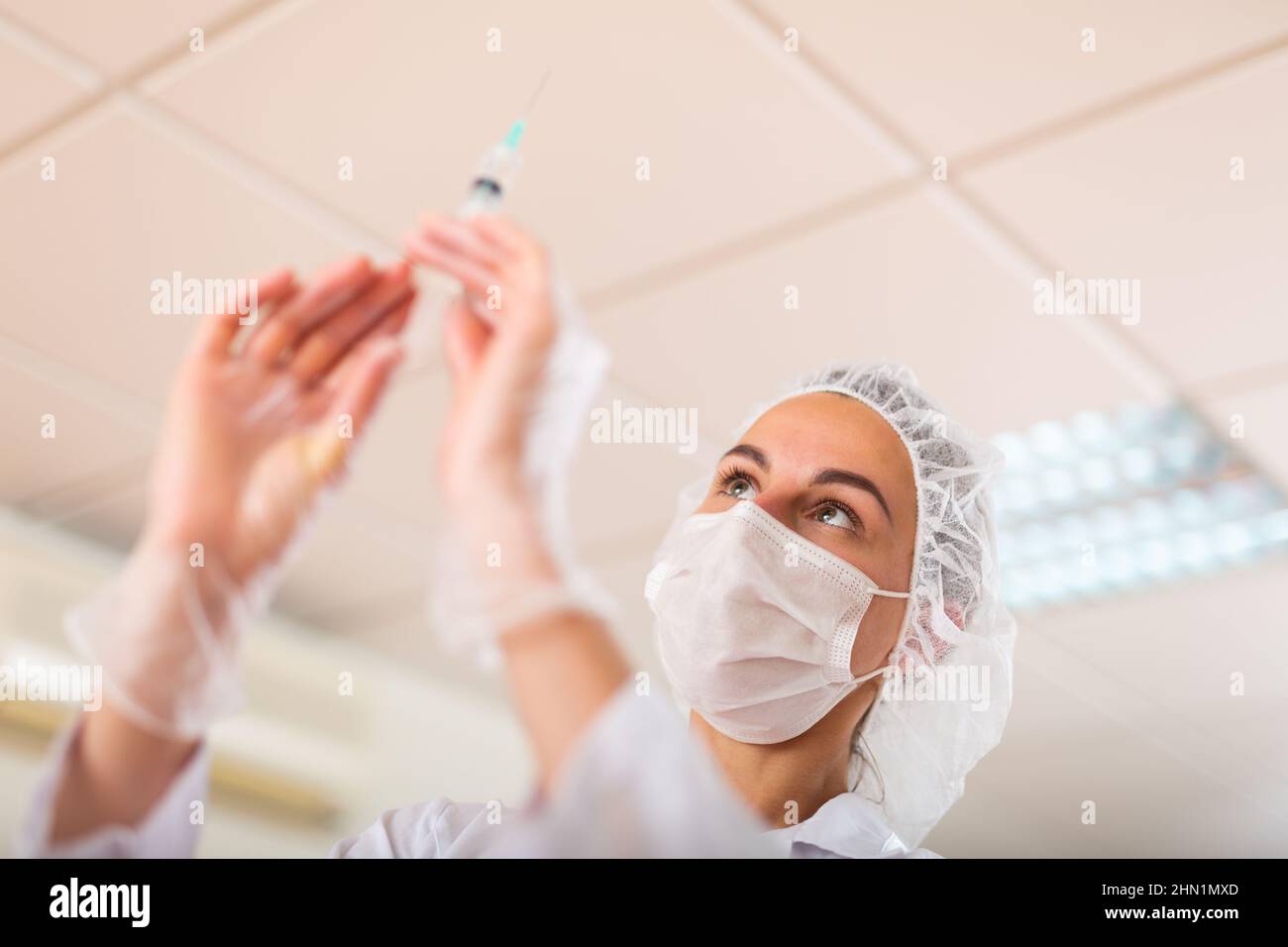 Nurse in mask holding syringe for injection in hospital Stock Photo - Alamy