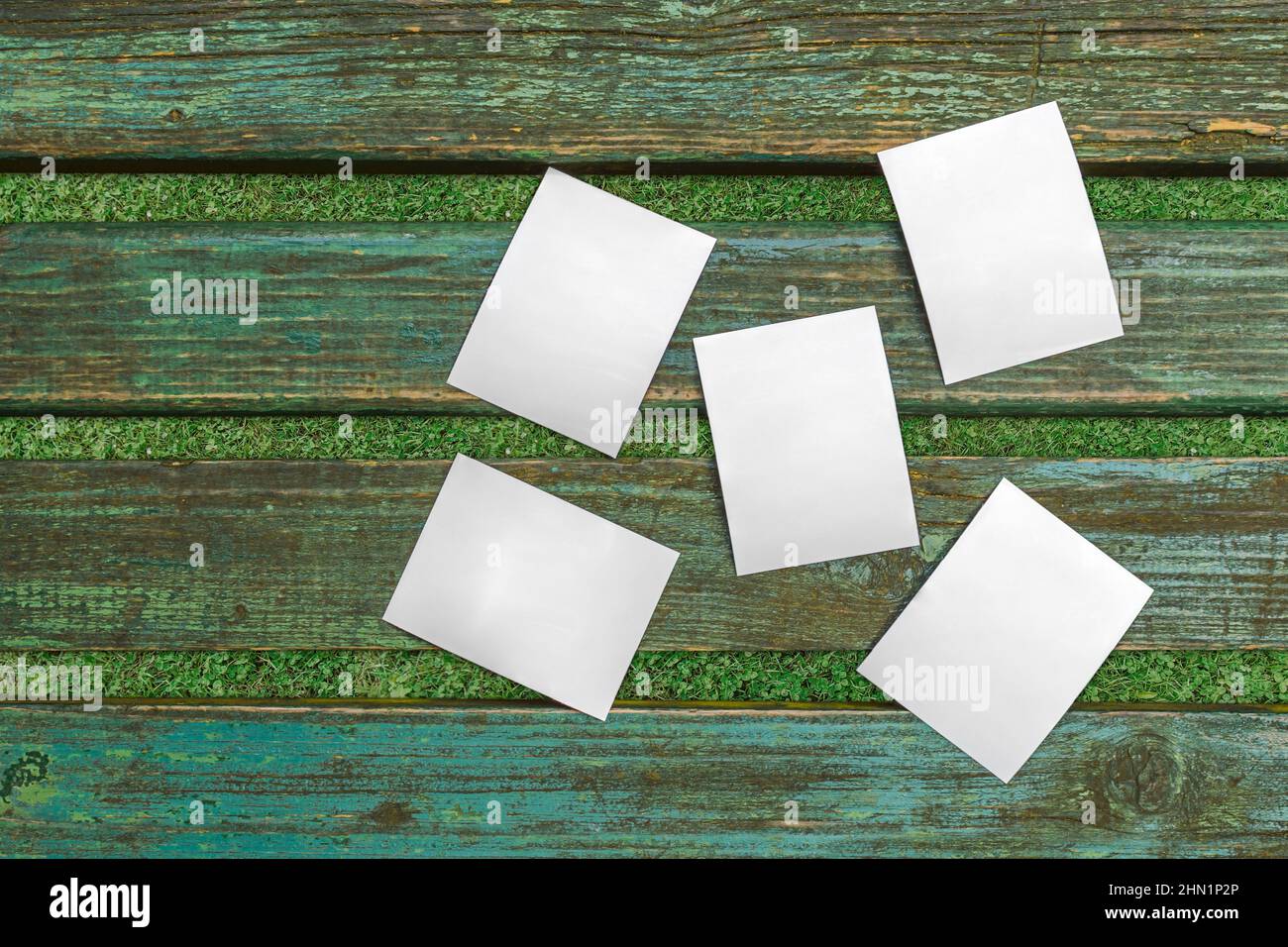 Five white paper picture frame of white paper on green wooden bench ...