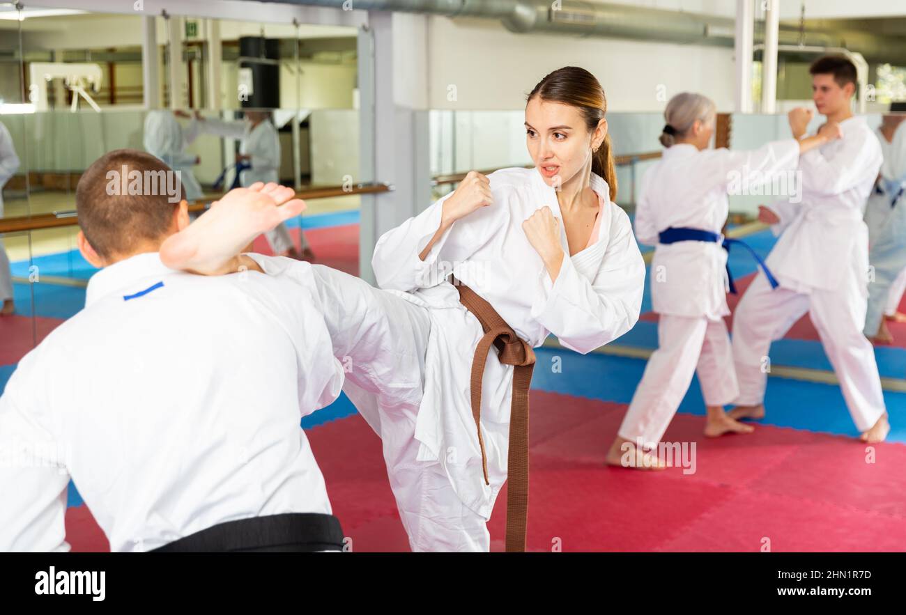 Young girl in white kimono practicing kicking with male opponent Stock Photo - Alamy