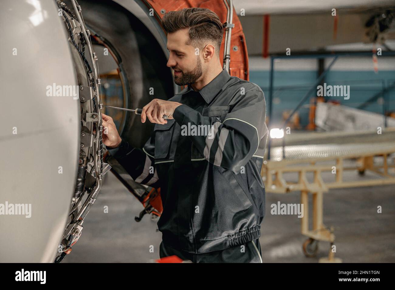 Male aviation mechanic repairing aircraft in hangar Stock Photo - Alamy