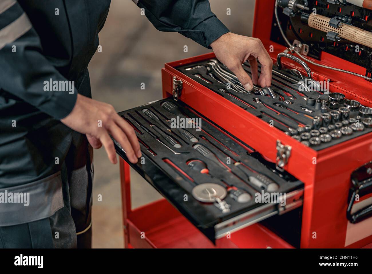 Male mechanic using tool box in hangar Stock Photo - Alamy