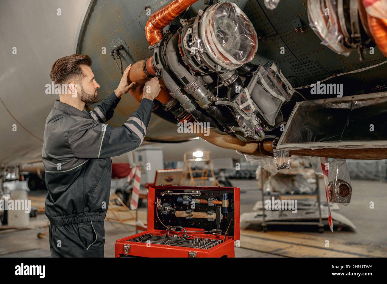 Male aviation mechanic repairing airplane in hangar Stock Photo - Alamy