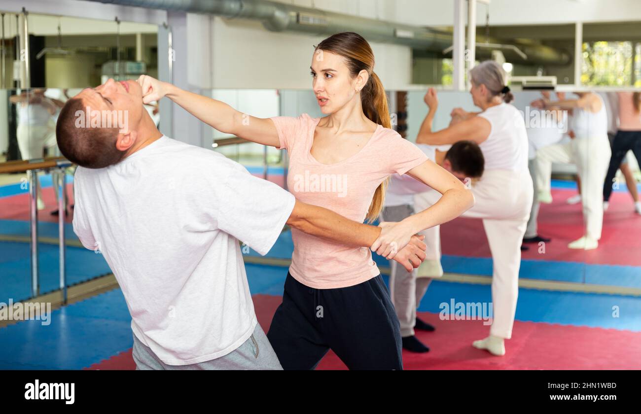 Girl blocking hand of male opponent, hitting chin with fist Stock Photo ...
