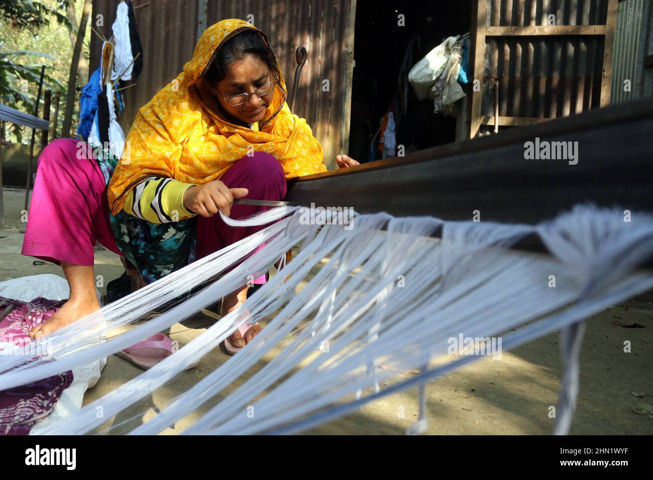 Workers prepare yarn to make cloth with yarn in a backyard Photo taken from Keraniganj in Dhaka ...
