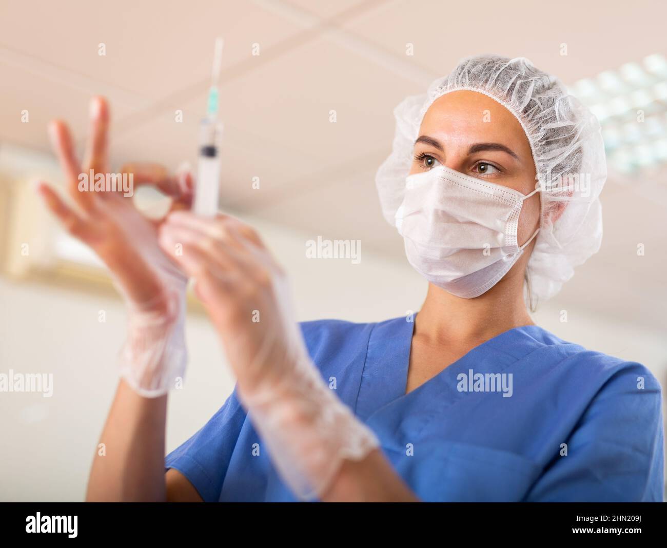 Nurse in mask holding syringe for injection in hospital Stock Photo - Alamy