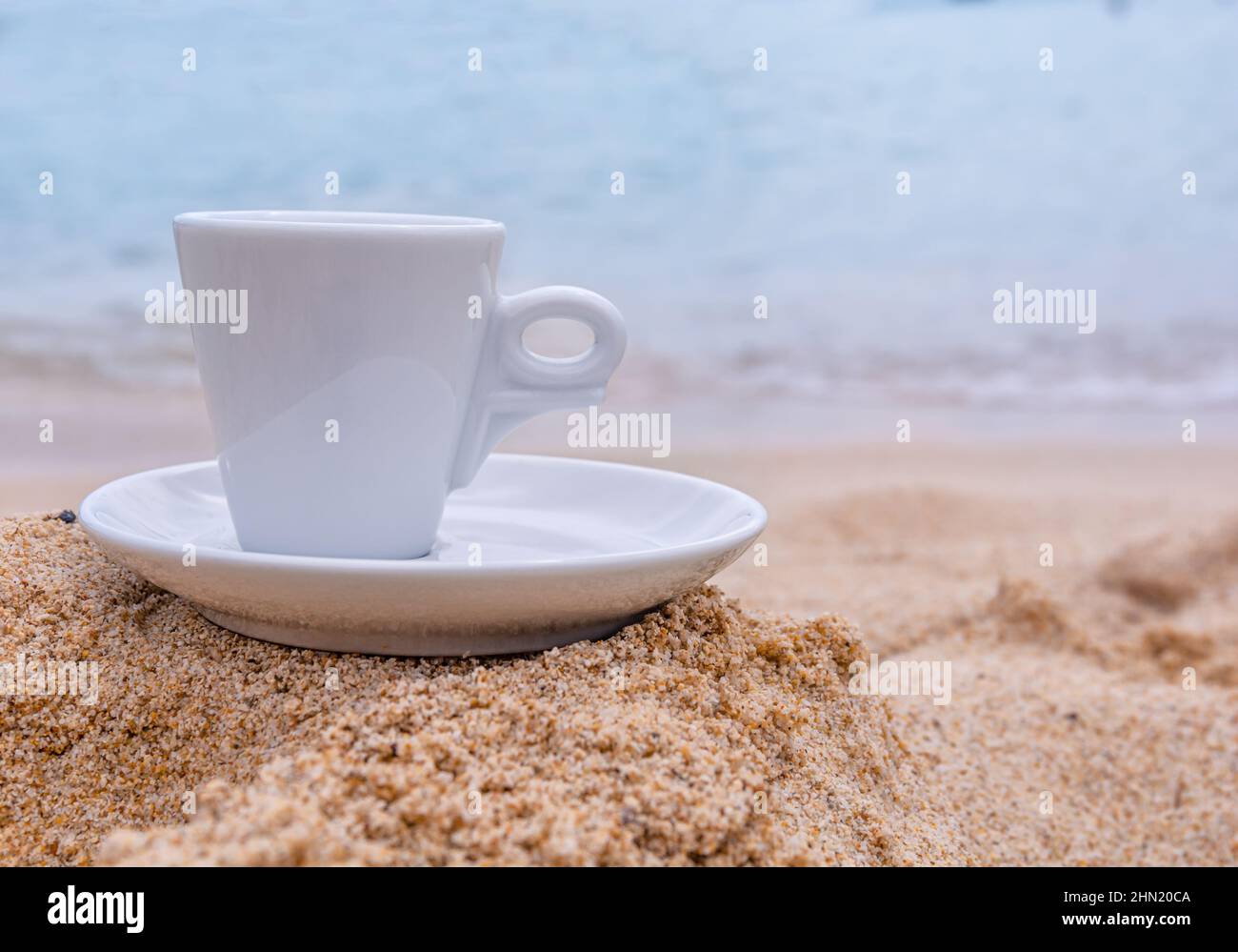 Coffee cup on the sand with sea background Stock Photo - Alamy
