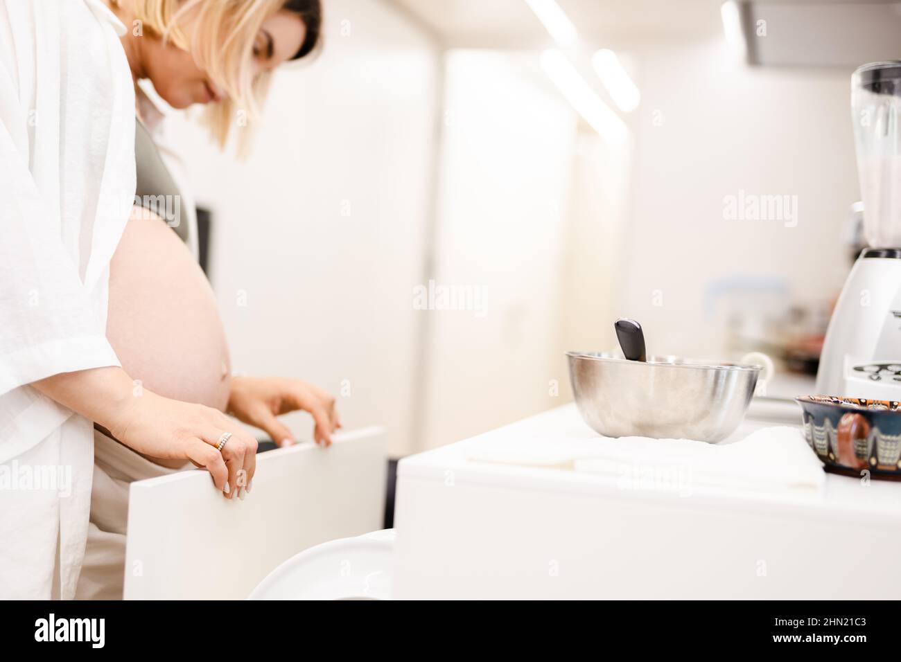 White blonde pregnant woman cooking in kitchen at home Stock Photo - Alamy