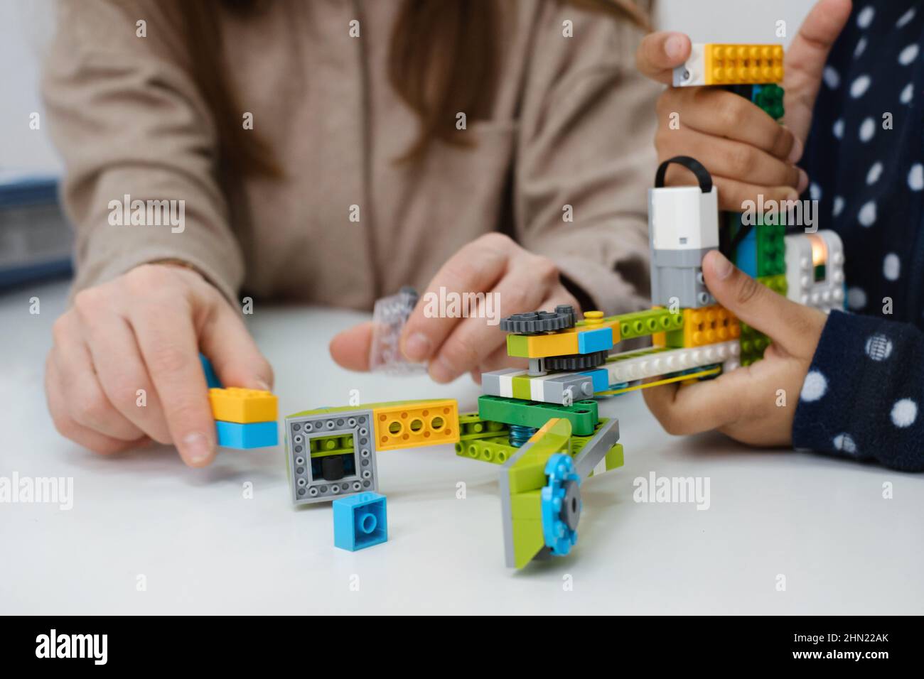 Coding Class, school girl constructing robot arm mechanism. multiethnic ...