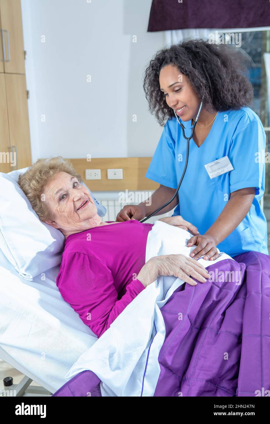 Caucasian female senior smiling with female african doctor at the ...