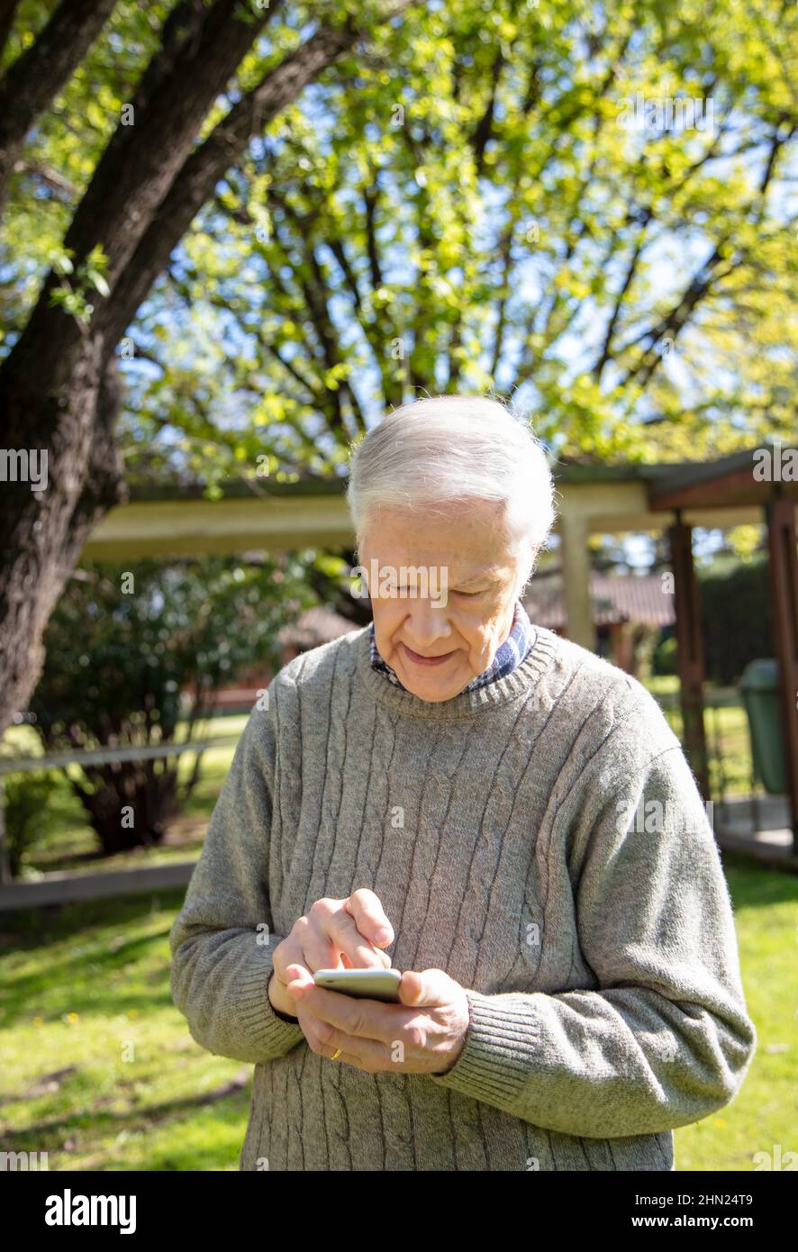 Senior outdoor playing with smartphone. Retired elderly people living ...