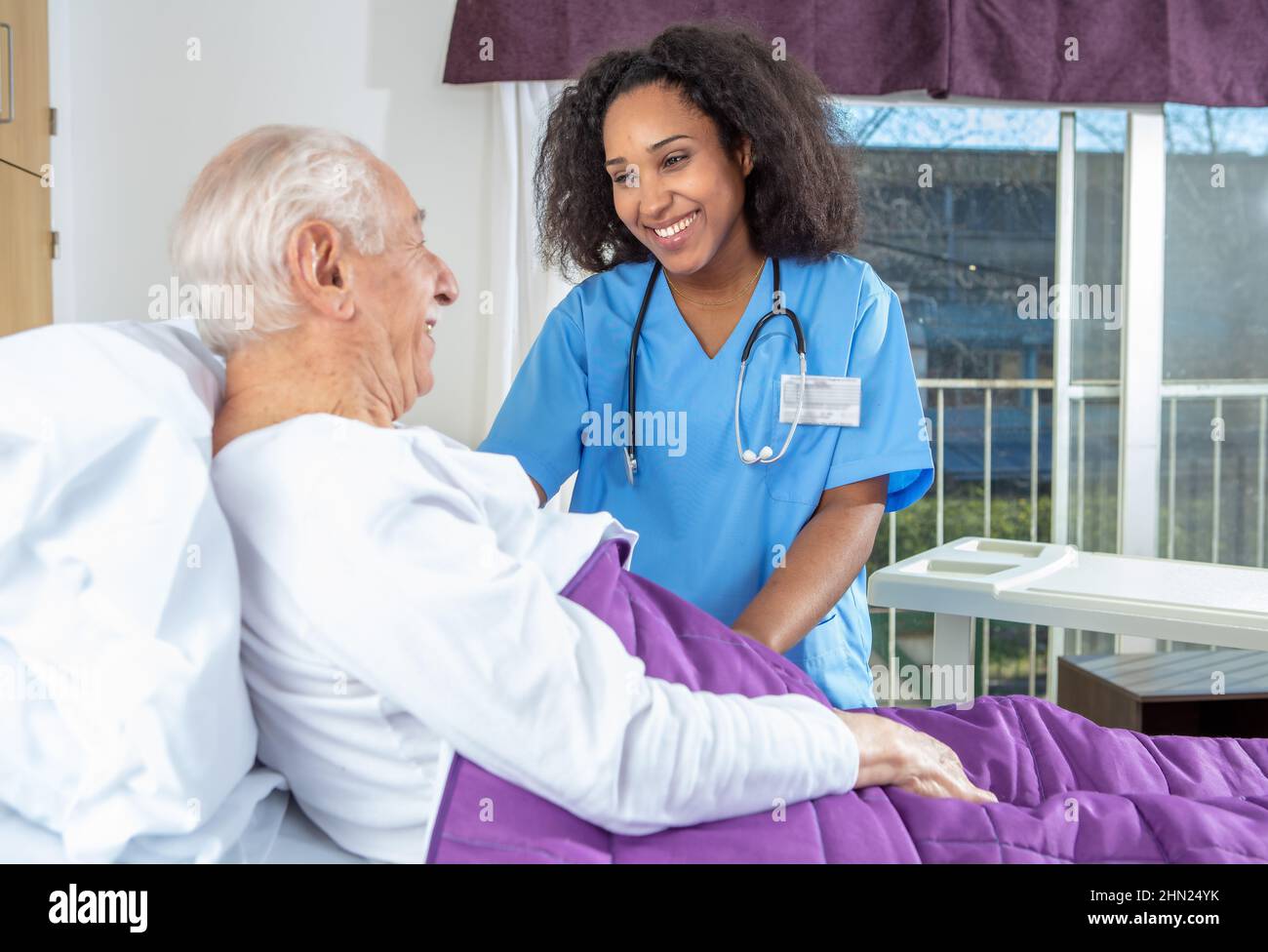 Caucasian senior smiling with doctor at the hospital. Retired elderly ...