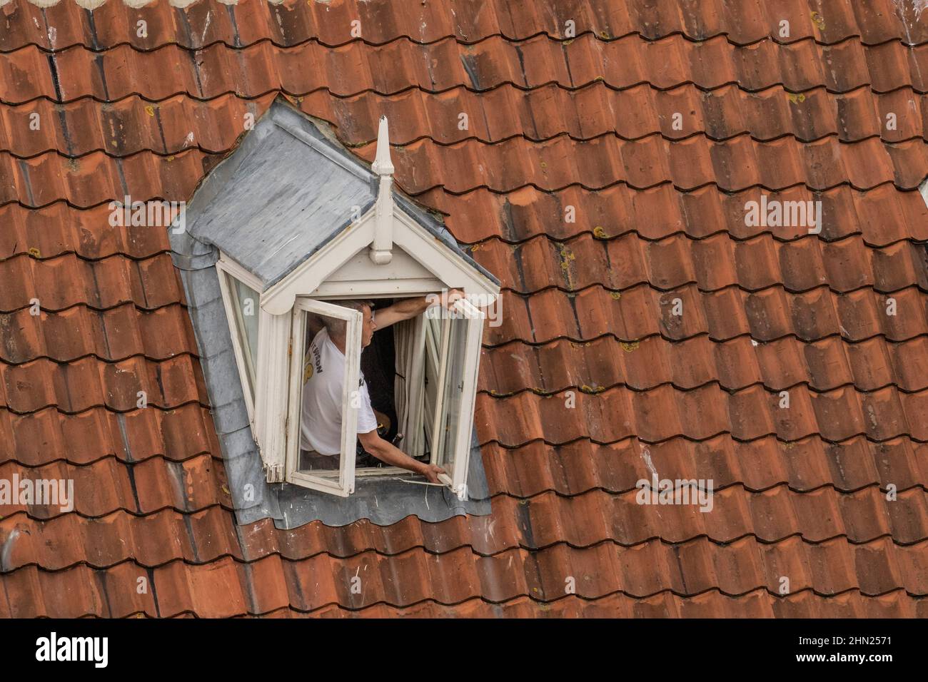 New window being fitted into a roof Dorma window in Whitby. Man holding ...