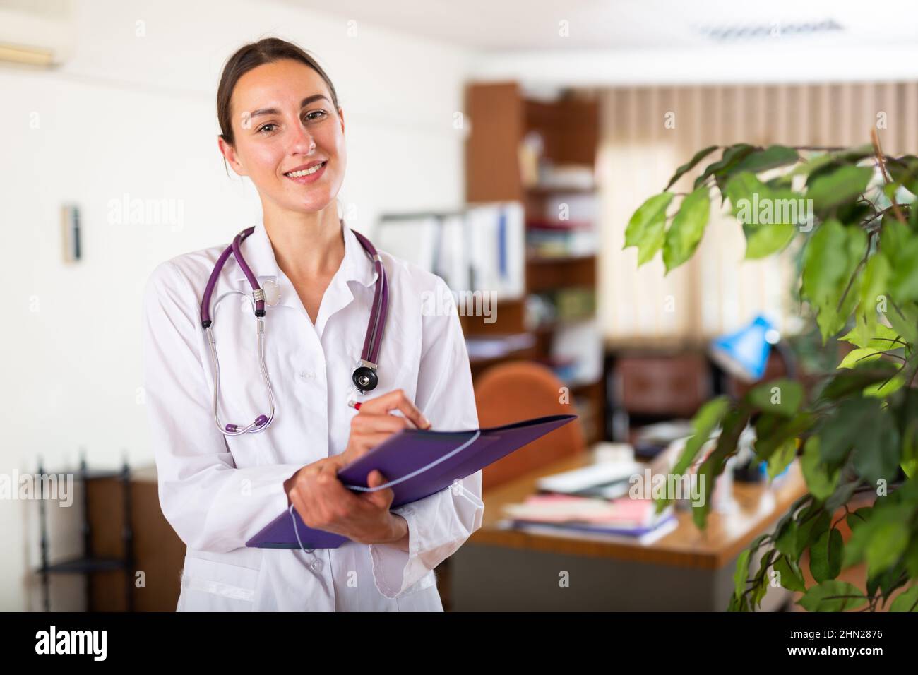Woman doctor wear white medical uniform with folder of documents Stock ...