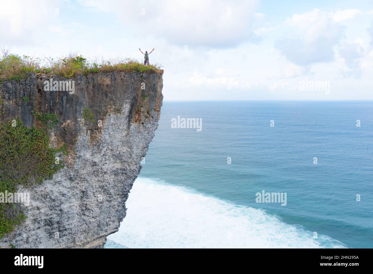 a man standing on a cliff watching the ocean Stock Photo - Alamy