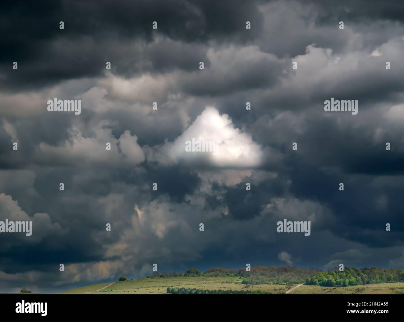 a foreboding dramatic dark grey thunder storm cloud sky over a tump and ...