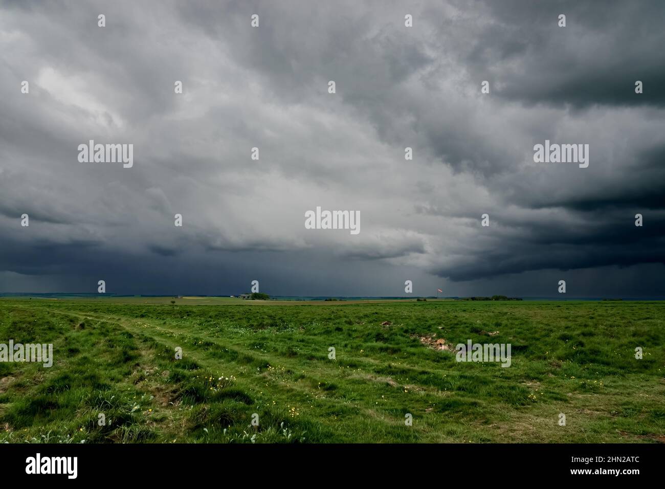 a foreboding dramatic dark grey thunder storm cloud sky over an open ...