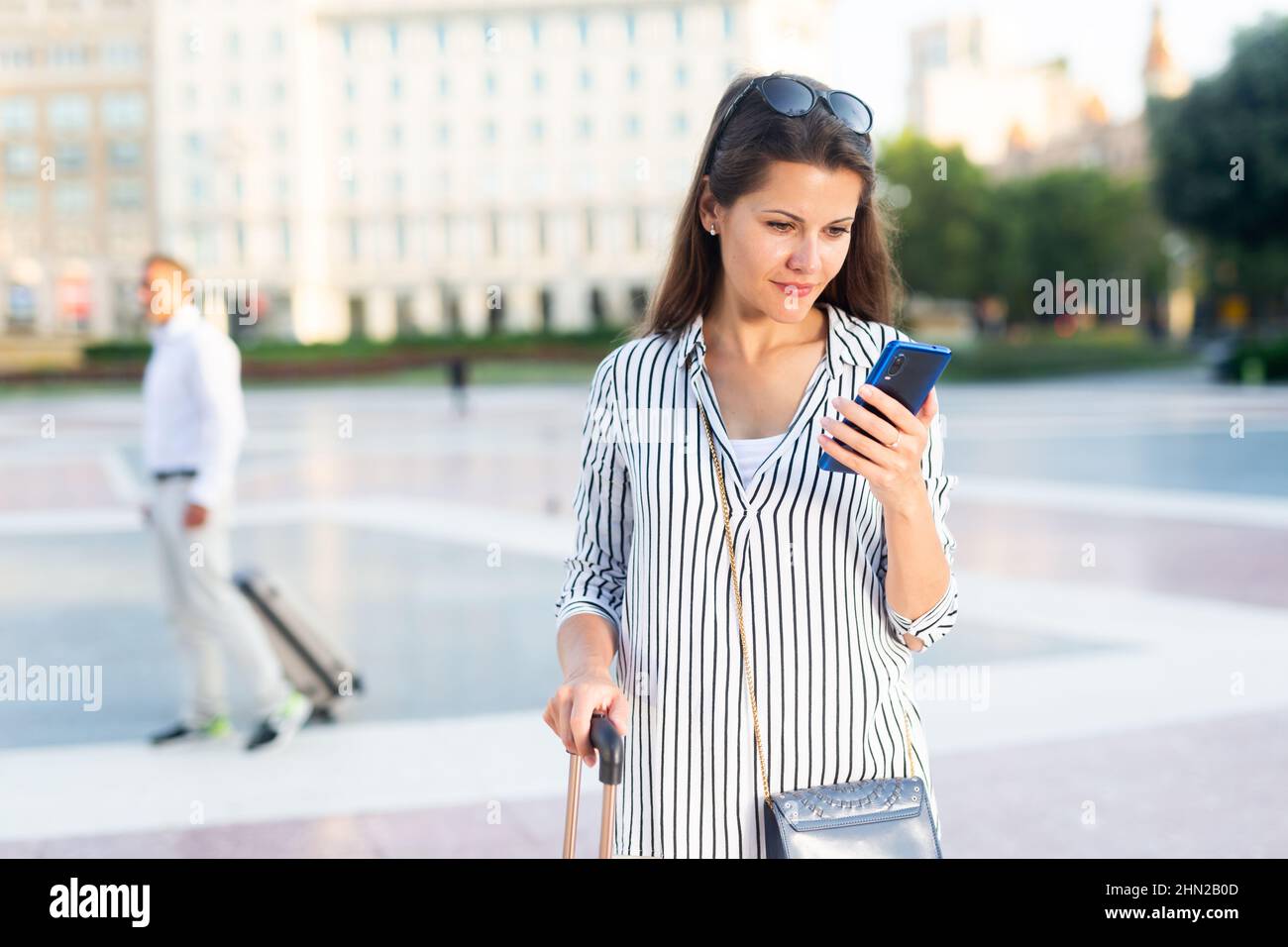 Interested female traveler reading about sights in smartphone Stock ...