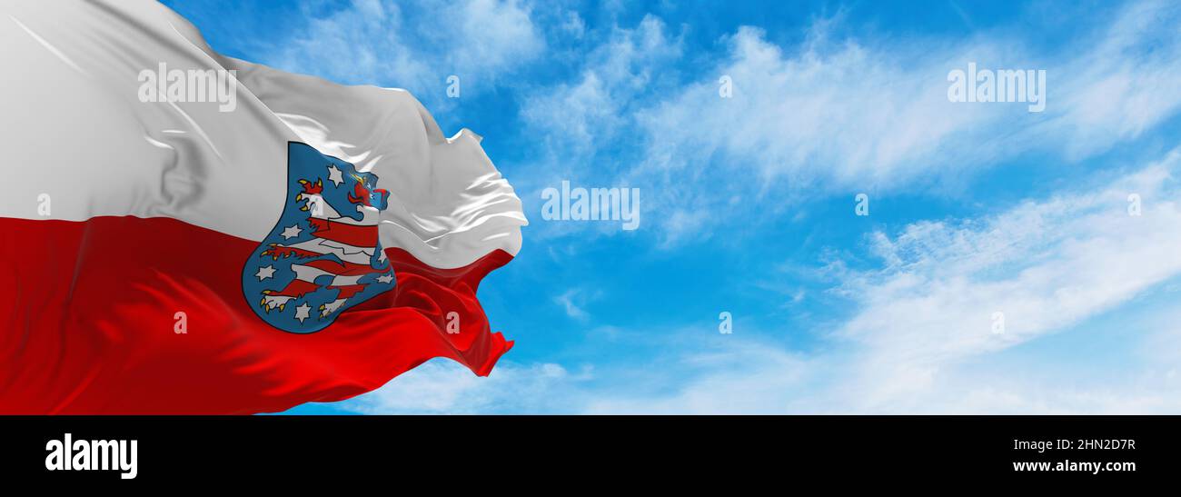 flag of Thuringia, state at cloudy sky background on sunset, panoramic ...