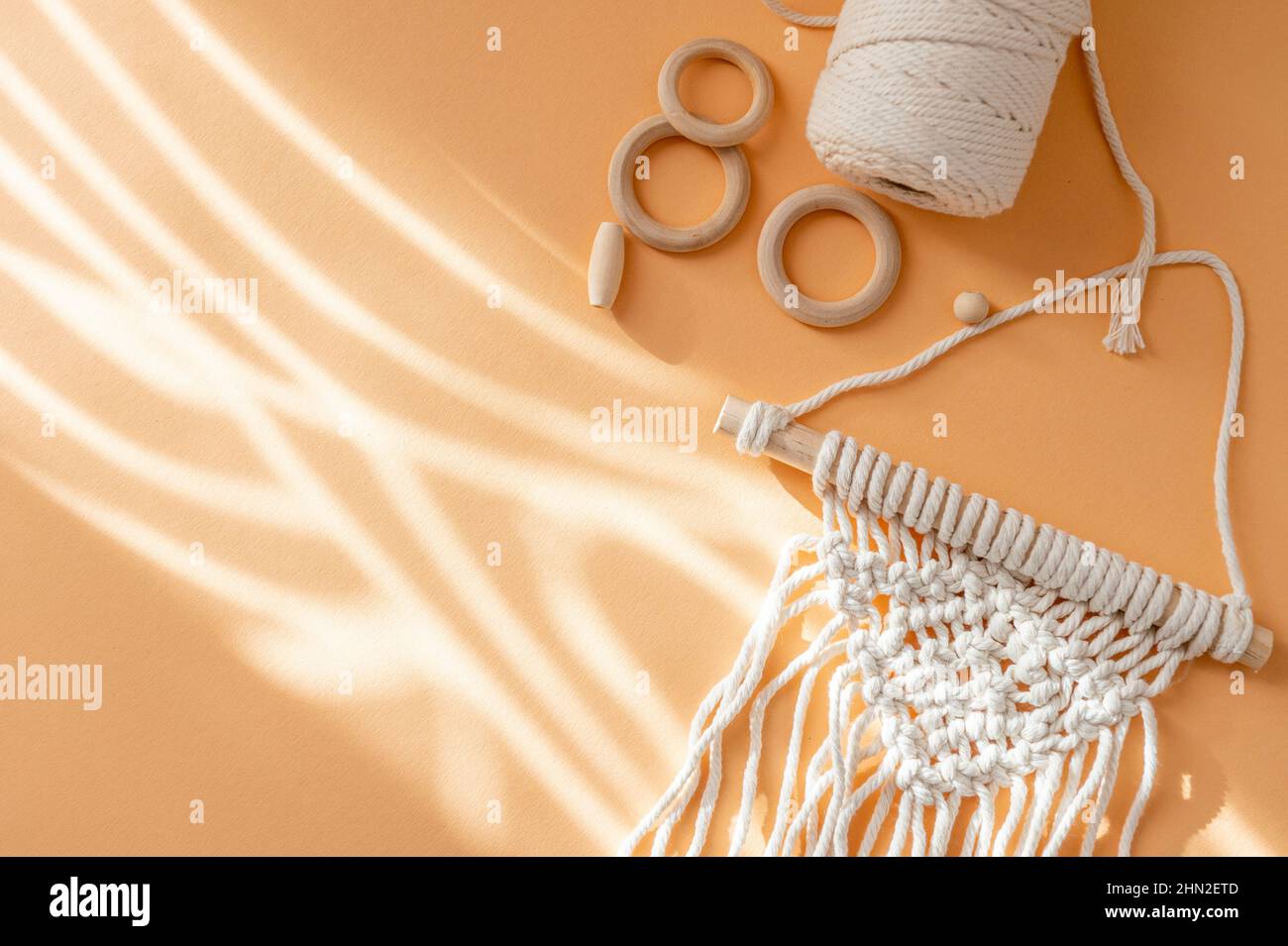 Macrame accessories on beige background. Creative hobby concept. Top ...