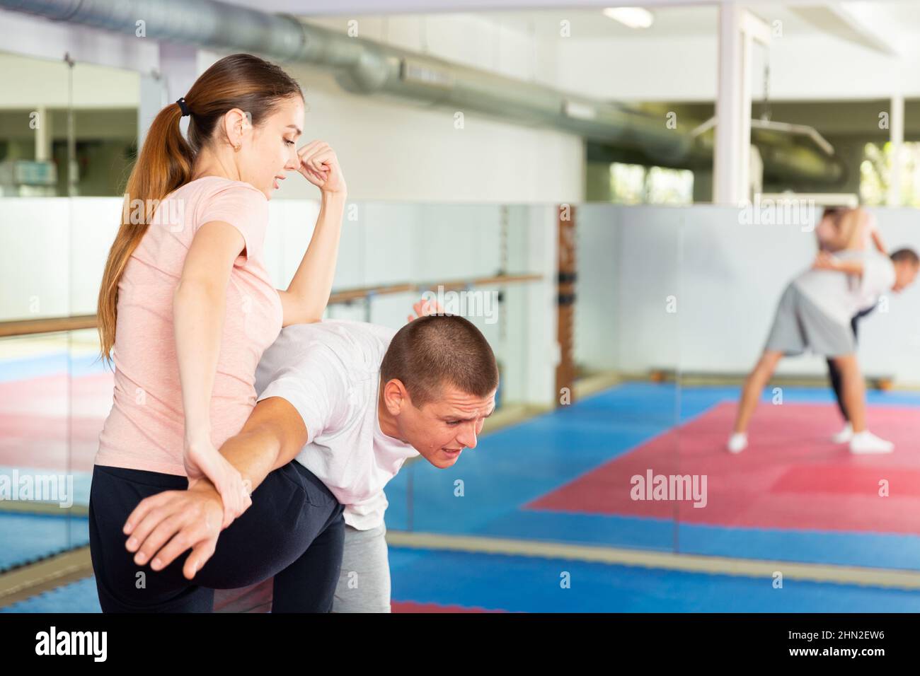 Girl practicing elbow and knee strikes with arm hold to male sparring ...
