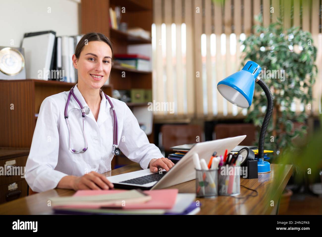 Young female therapist is sitting at workplace in the resident's office ...
