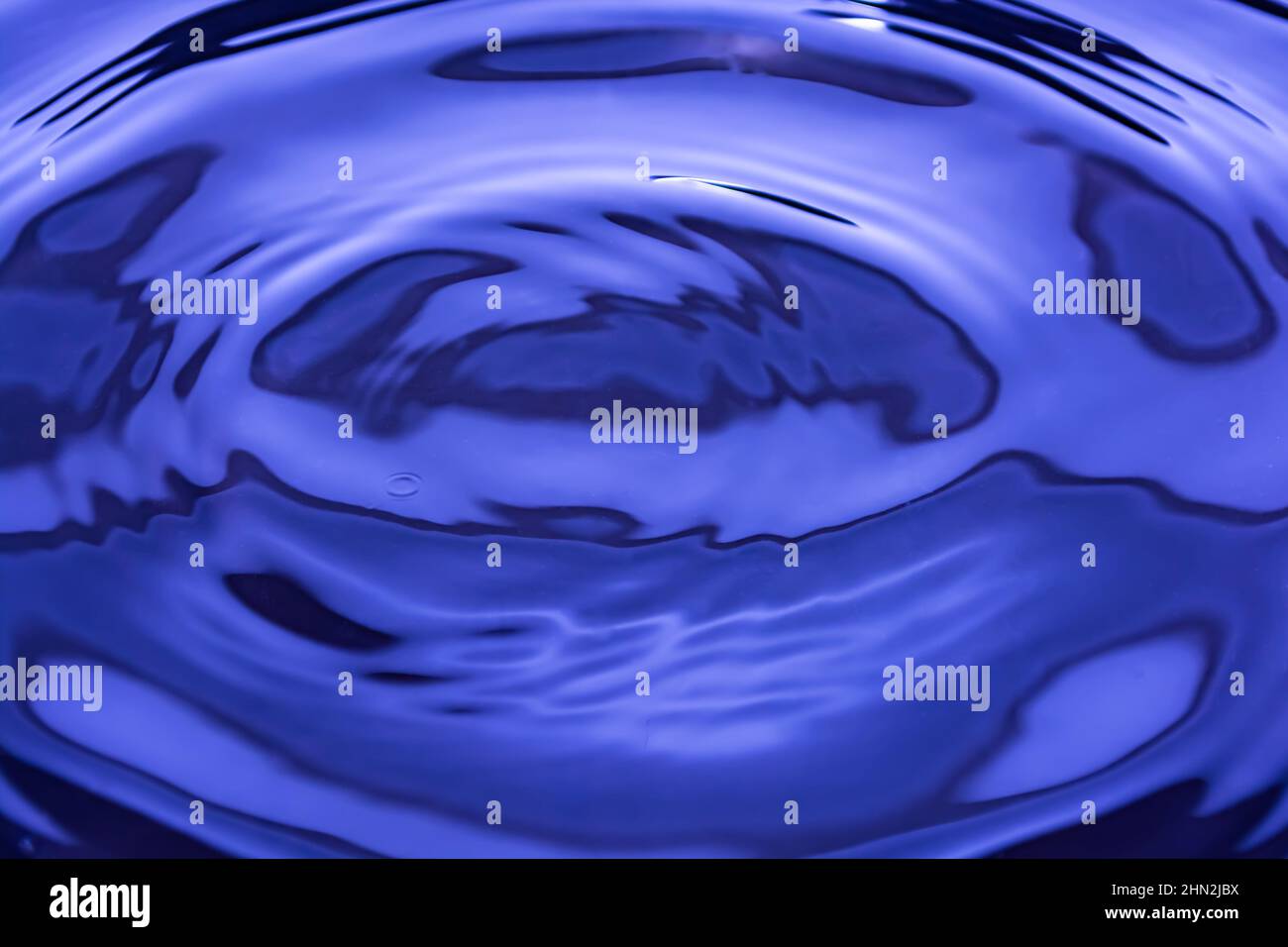 Beautiful liquid blue background with glitter. Small circular water ...