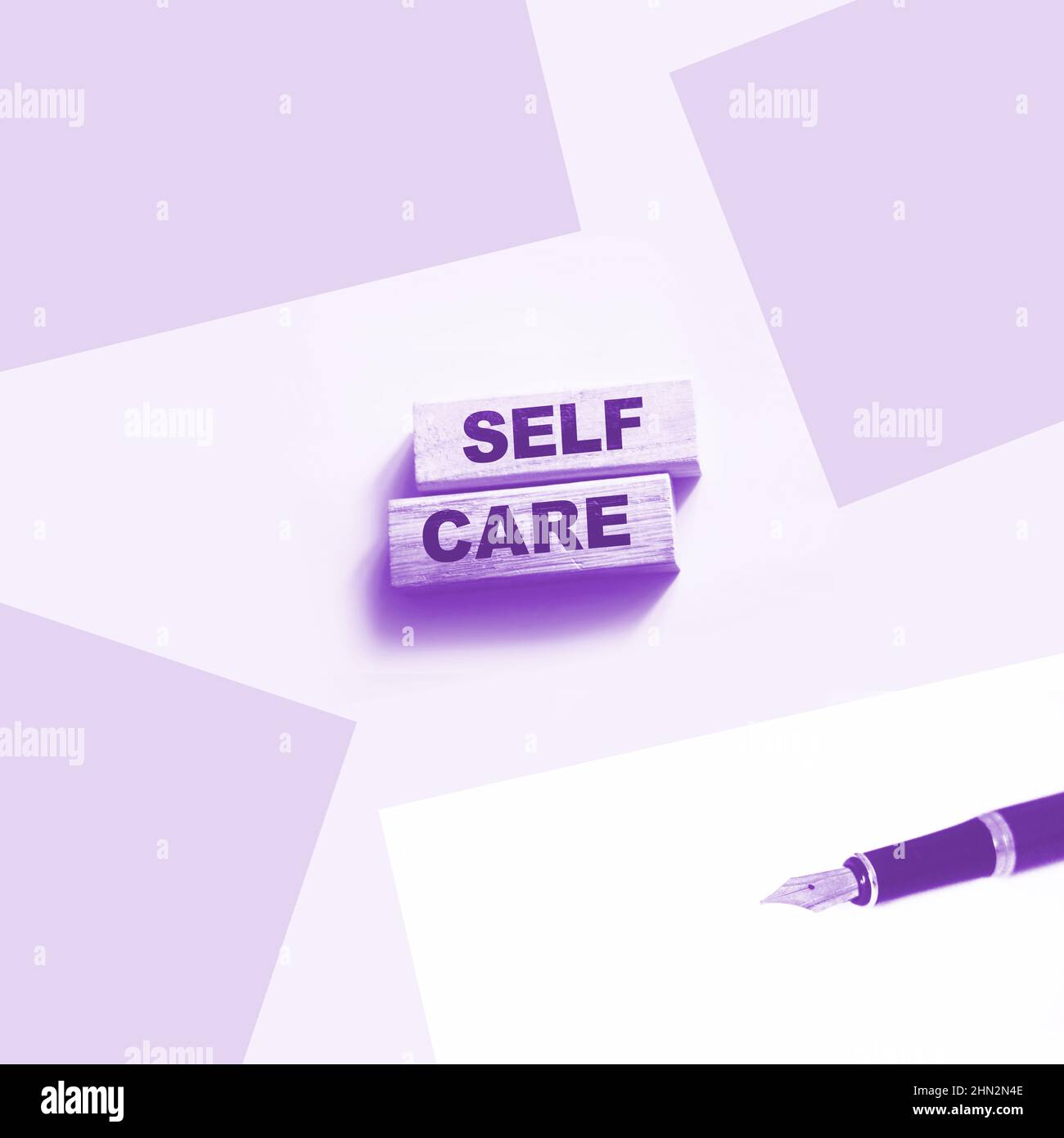 Self care words printed on wooden blocks, self treatment concept, pink ...