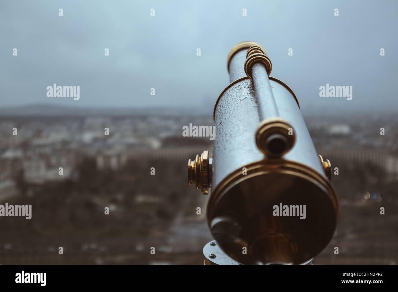 Old metal monocular with rain drops on a blurry urban landscape Stock ...