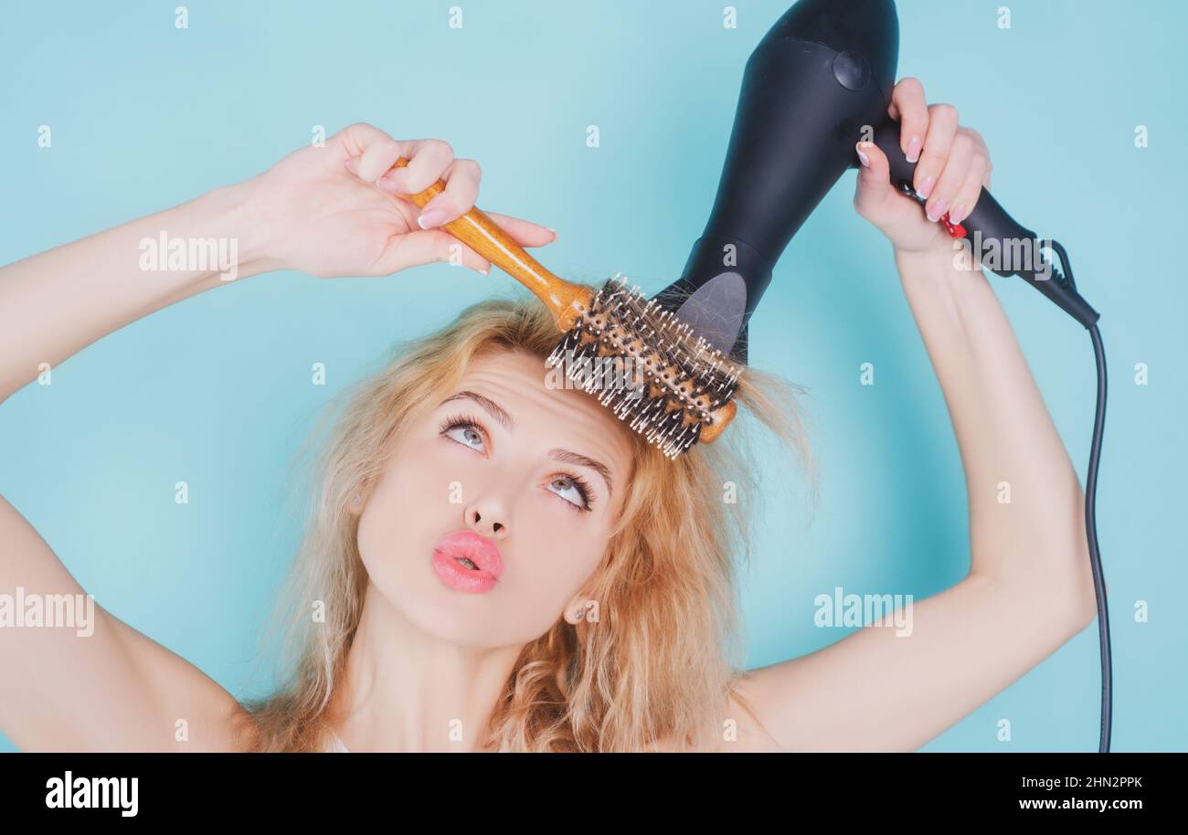 Young funny woman using hair dryer. Young girl with drying hair with ...