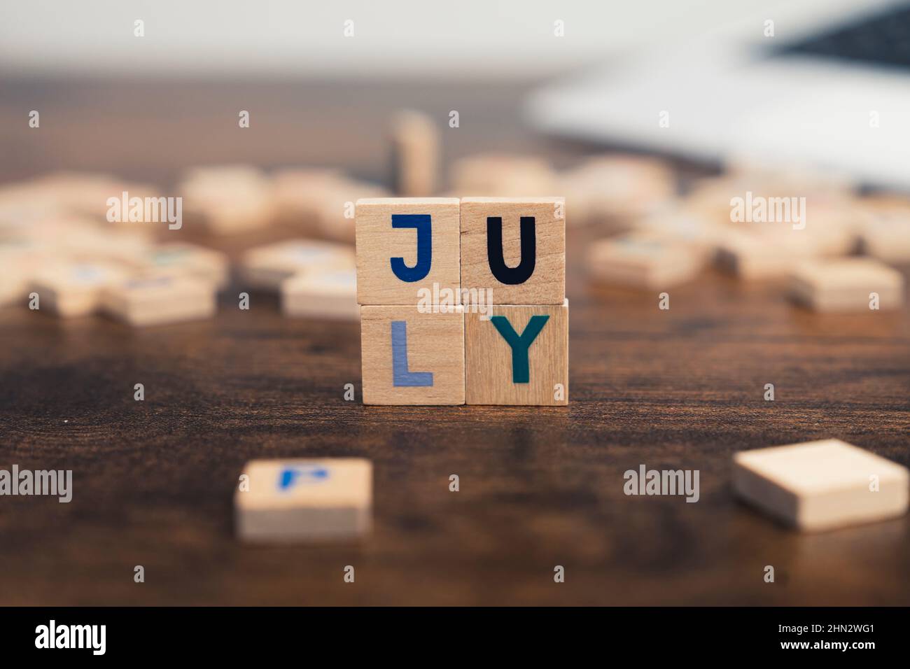 The name of the month July written on wooden cubes od the tabletop of ...