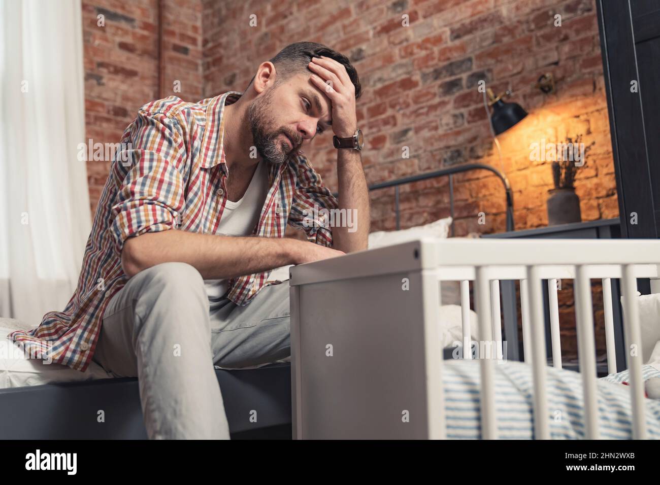 middle-aged caucasian father worried about his little baby's illness ...