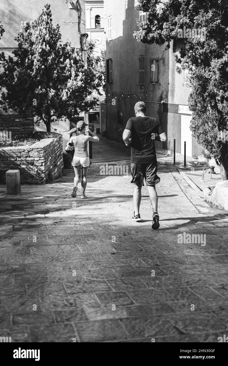 Vertical grayscale shot of runners in an empty street Stock Photo - Alamy