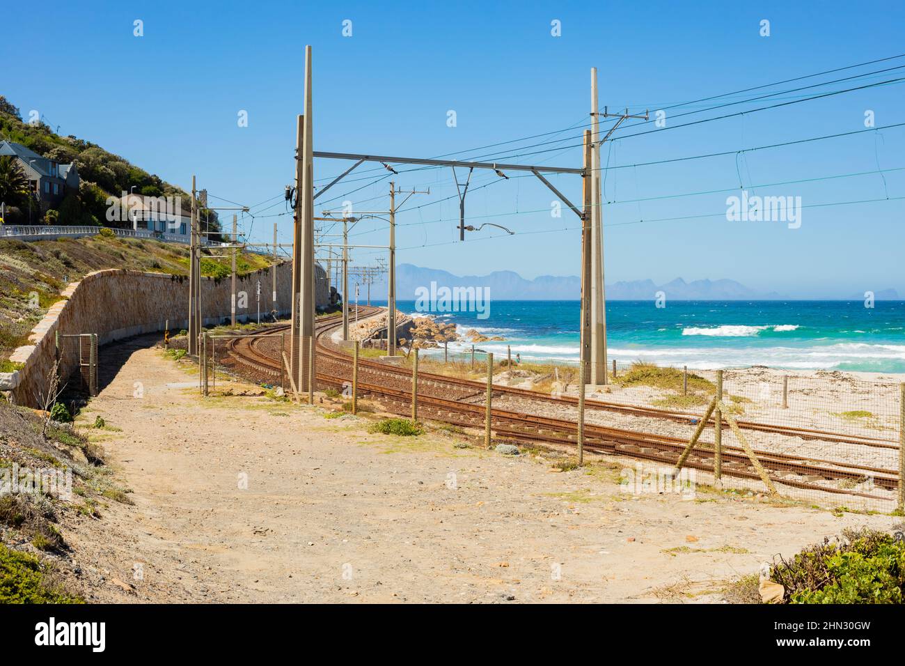 Passenger railway running along beach in small coastal town of Fish ...