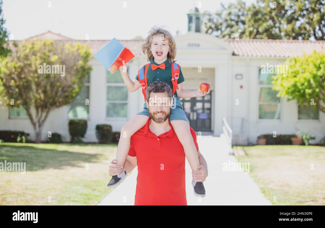Father and son piggyback ride trough school park Stock Photo - Alamy
