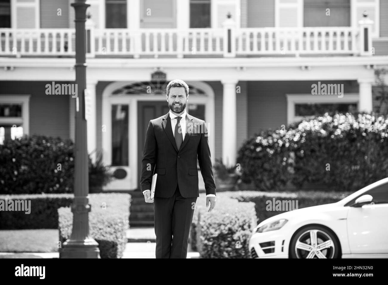 Real estate. Agent ready to sell home. Businessman standing outside a ...