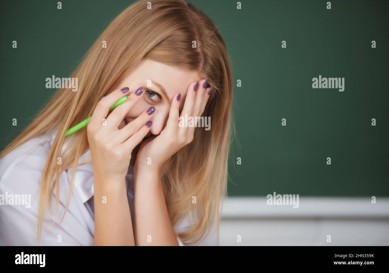 Portrait of a young shame embarrassed female student studying in school ...