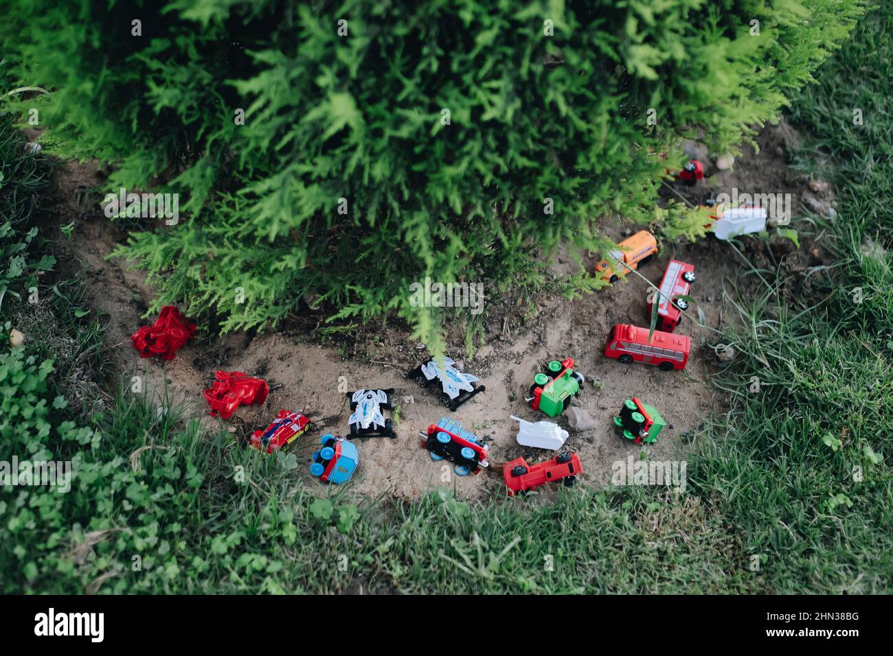 Top view of garden bushes with many plastic toys cars, baby play ...