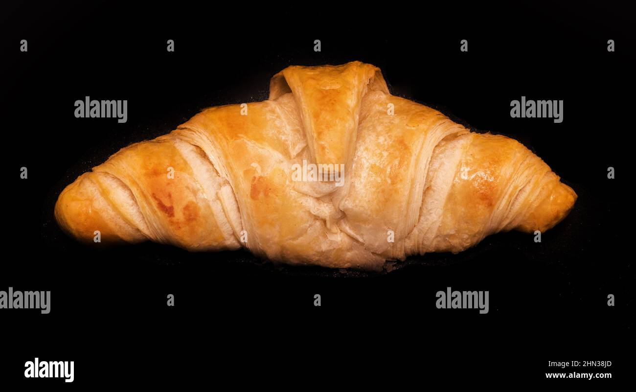 Single freshly baked butter croissant pastry on black background Stock ...