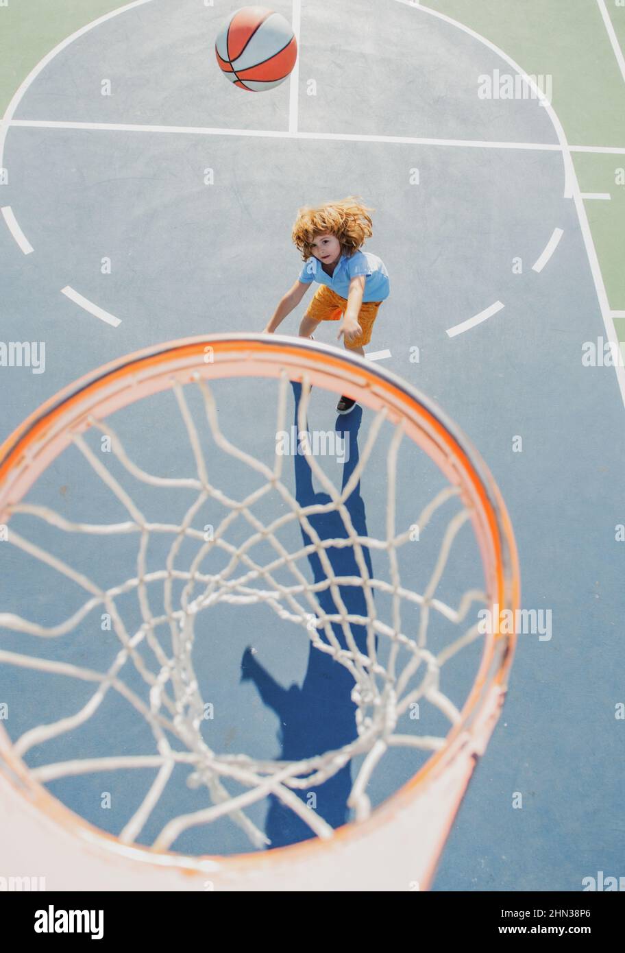 Child in basketball uniform jumping with basket ball for shot on ...