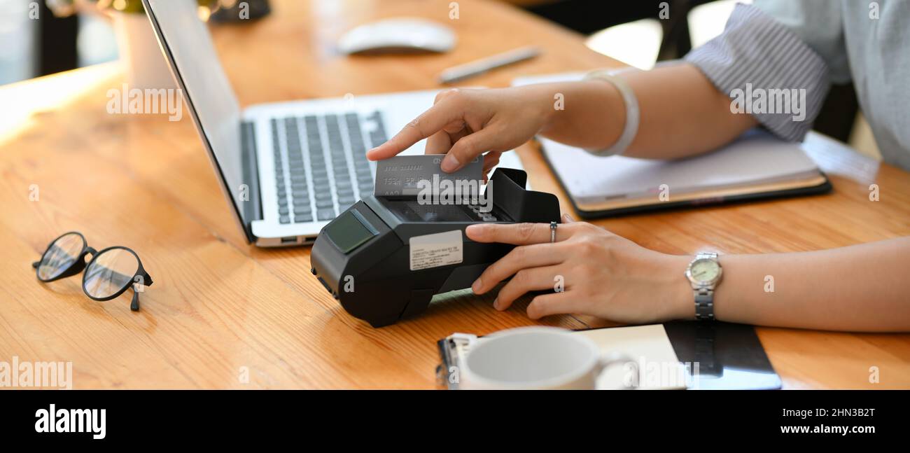 Close-up, Cashier or female banker swiping a credit card on payment ...