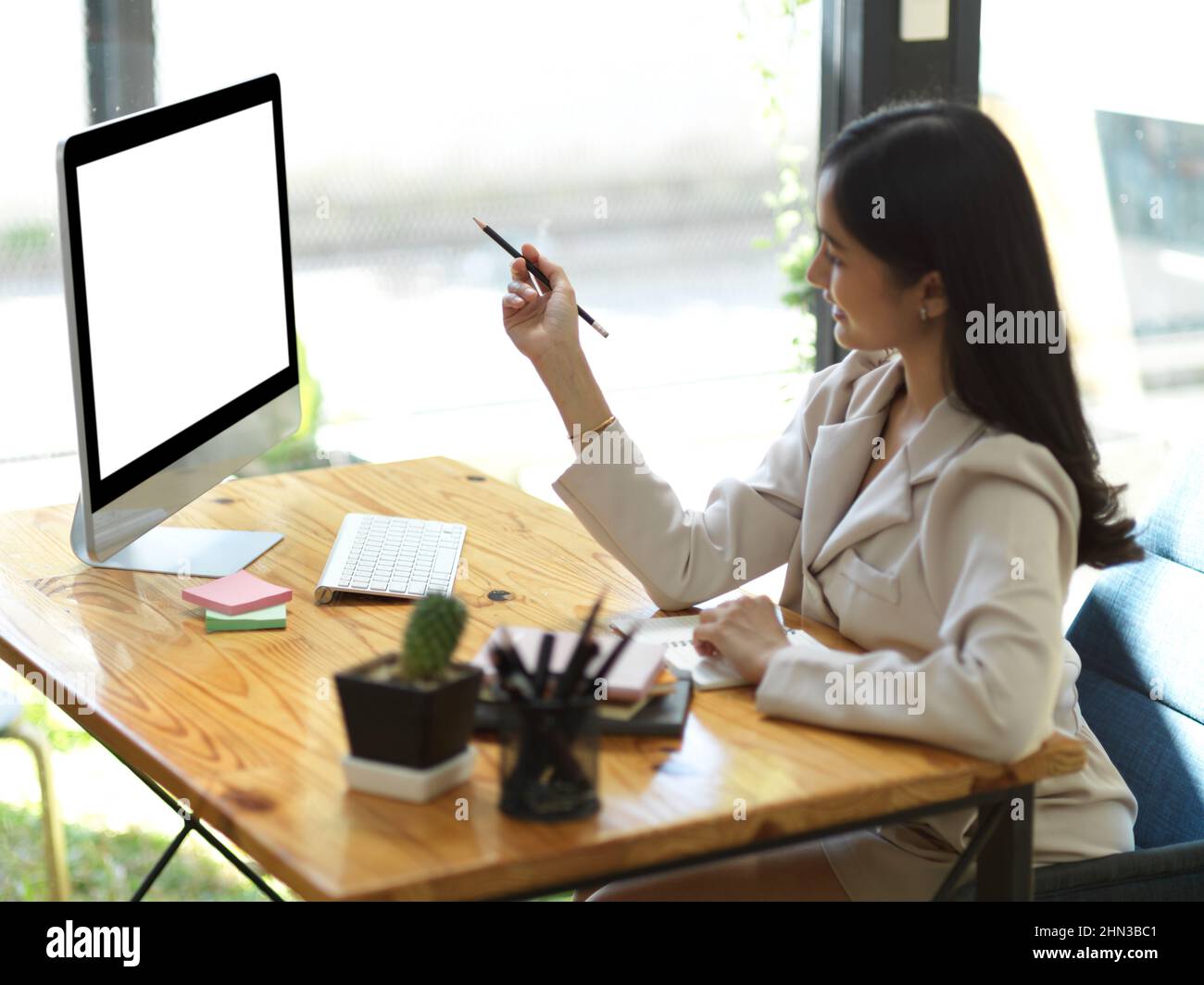 A beautiful female marketing officer looking at desktop screen, working ...
