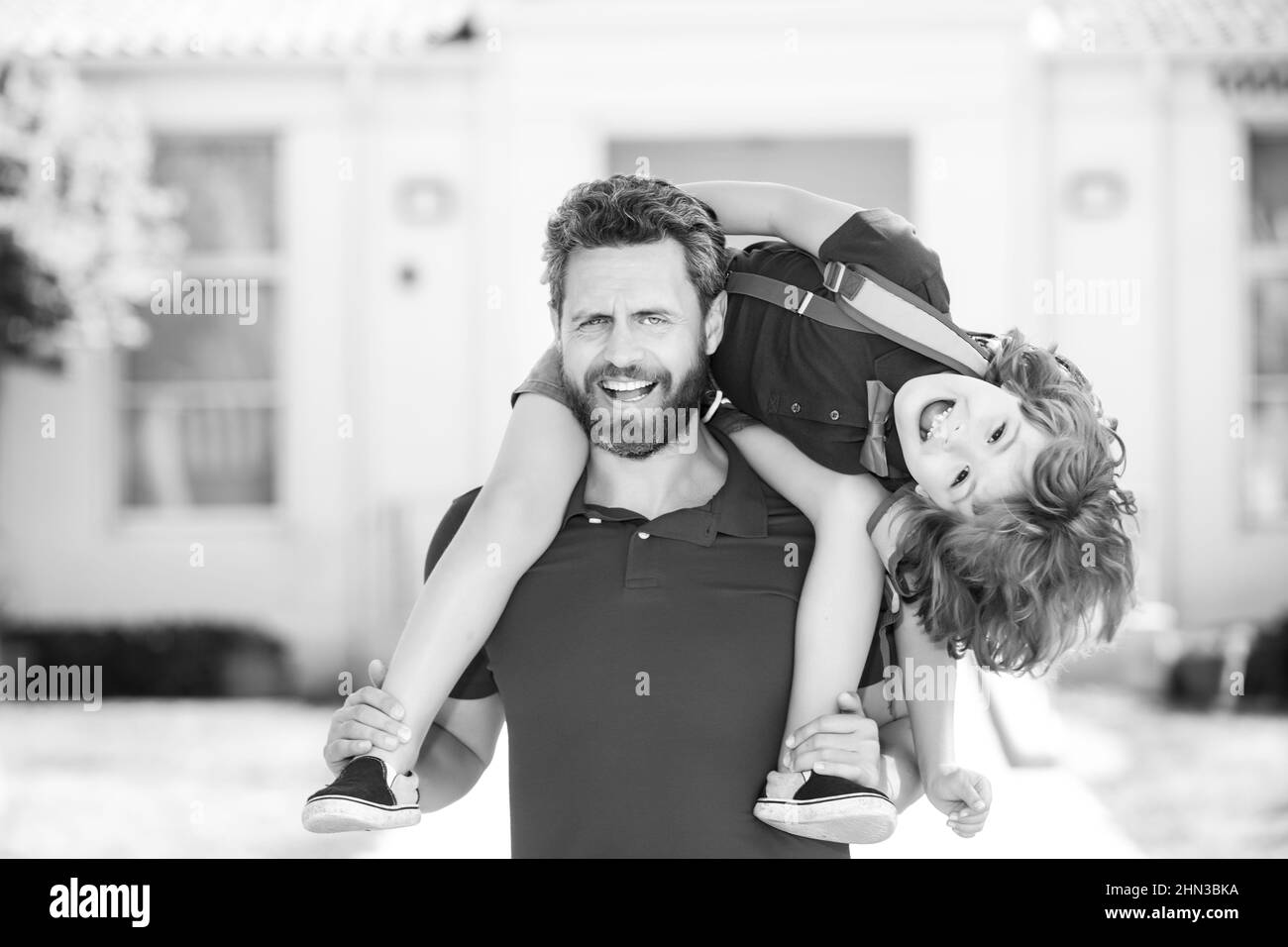 Father giving son piggyback ride after school study. Parent and pupil ...