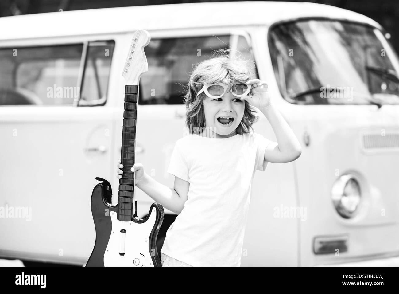 Future rock star. Excited child in pink shirt with electric guitar over ...