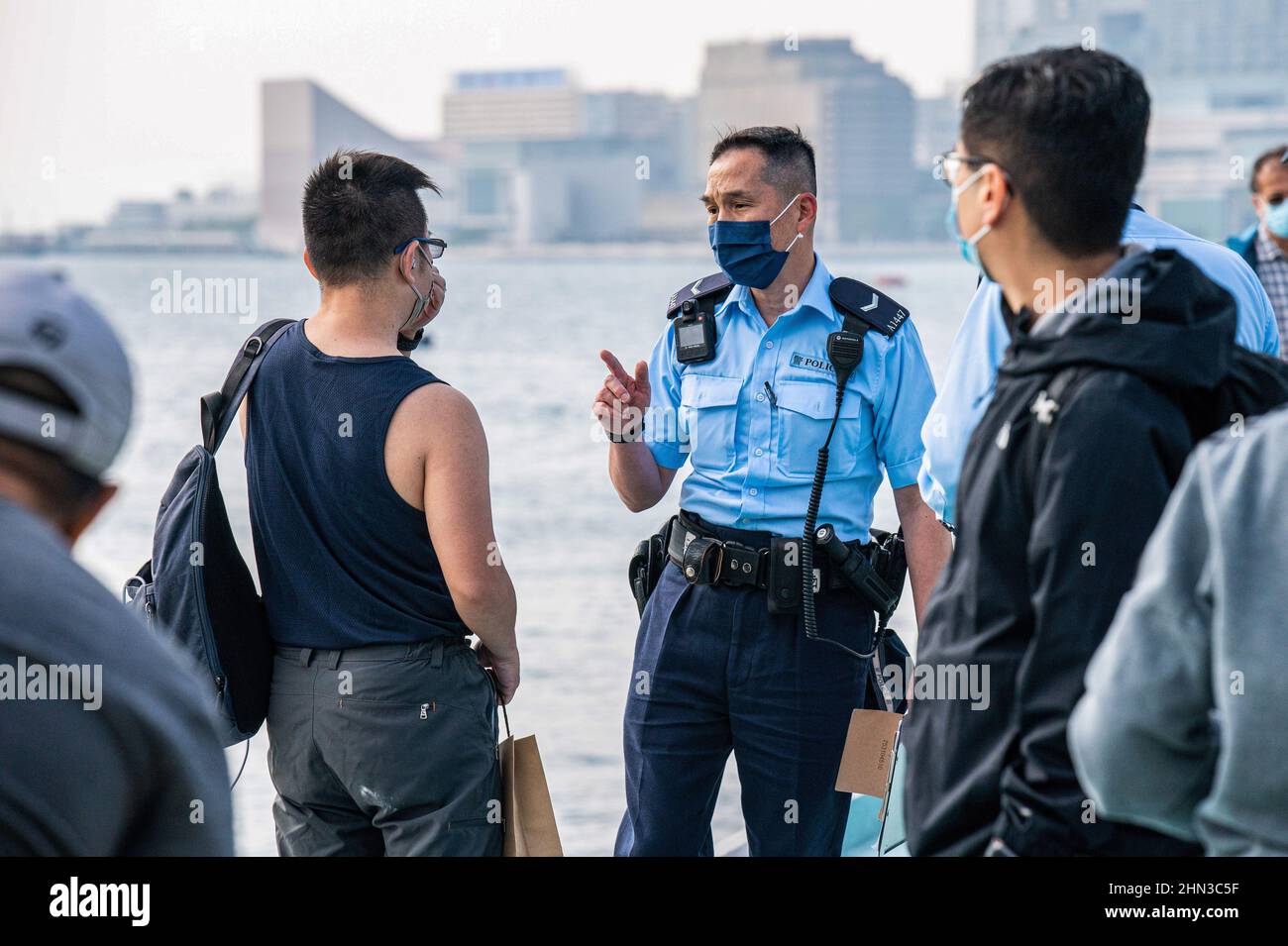 Hong Kong Police officer issues a verbal warning to a man found not ...